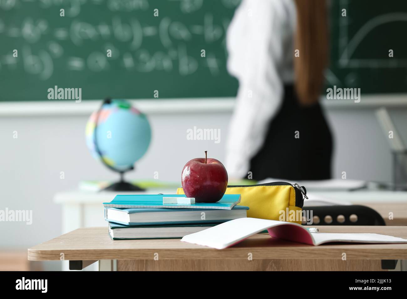 Apple with books and pencil case on table in classroom Stock Photo - Alamy
