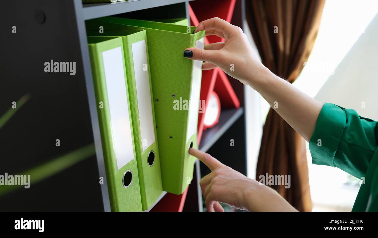 Woman hands taking off green paper folder Stock Photo - Alamy