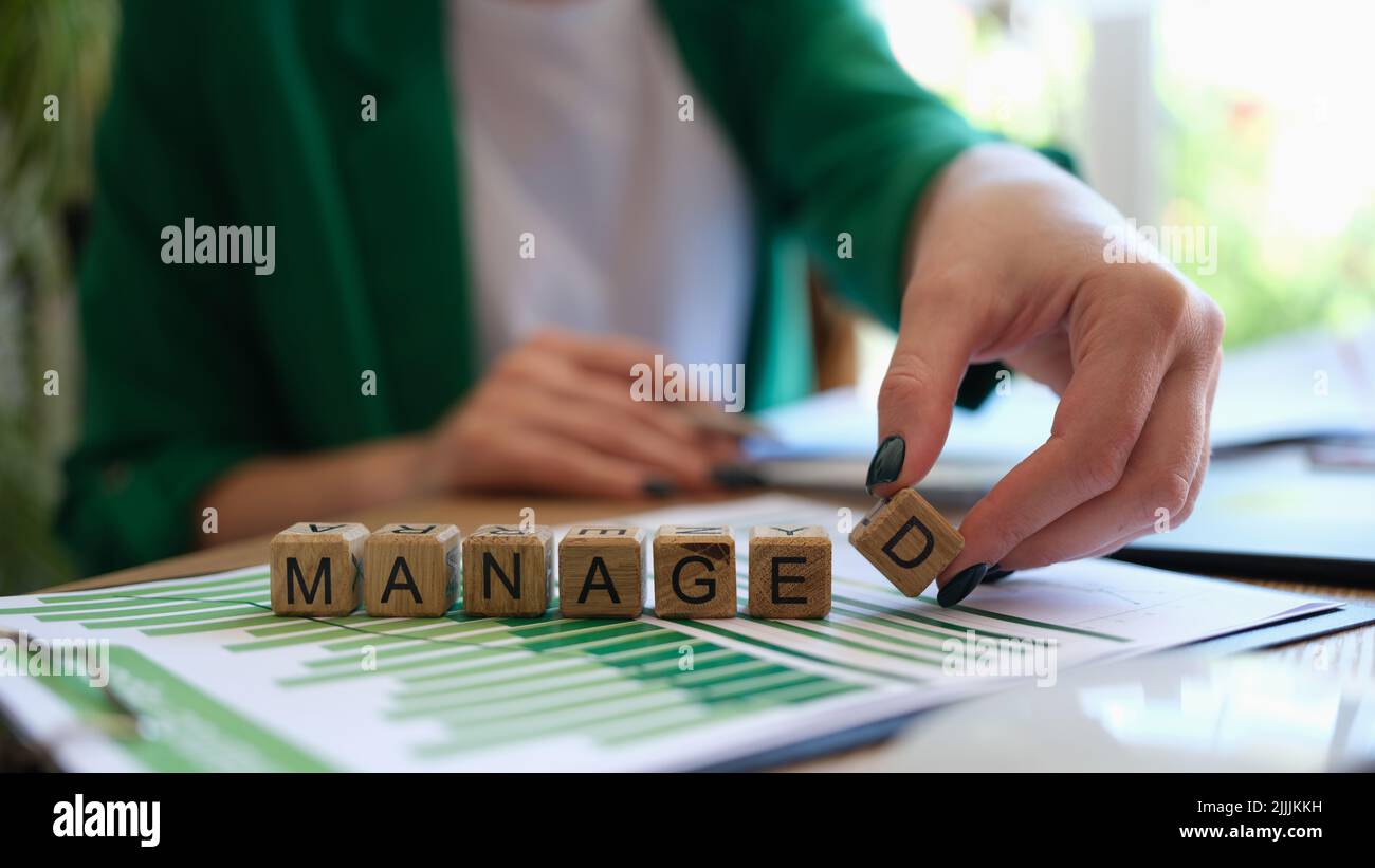 Woman collecting word managed with wooden cubes Stock Photo - Alamy