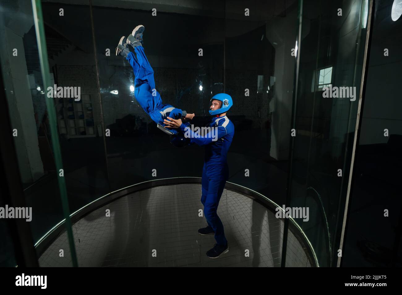 A man teaches a boy to fly in a wind tunnel. Lack of gravity Stock ...