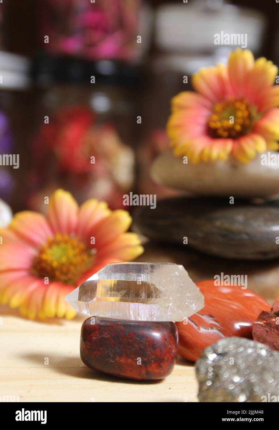 Quartz Crystal Balanced on Bloodstone With Flowers in Background Stock ...