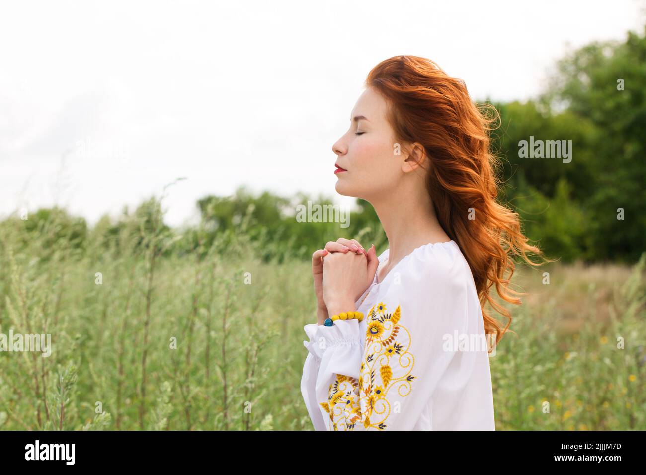 Red-haired, beautiful, young woman in a Ukrainian embroidered shirt ...