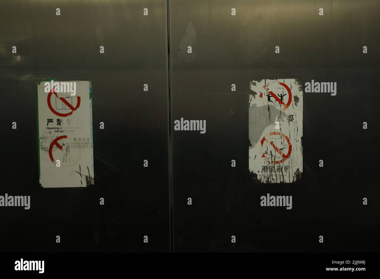 the inside of elevator doors with worn warning stickers Stock Photo - Alamy