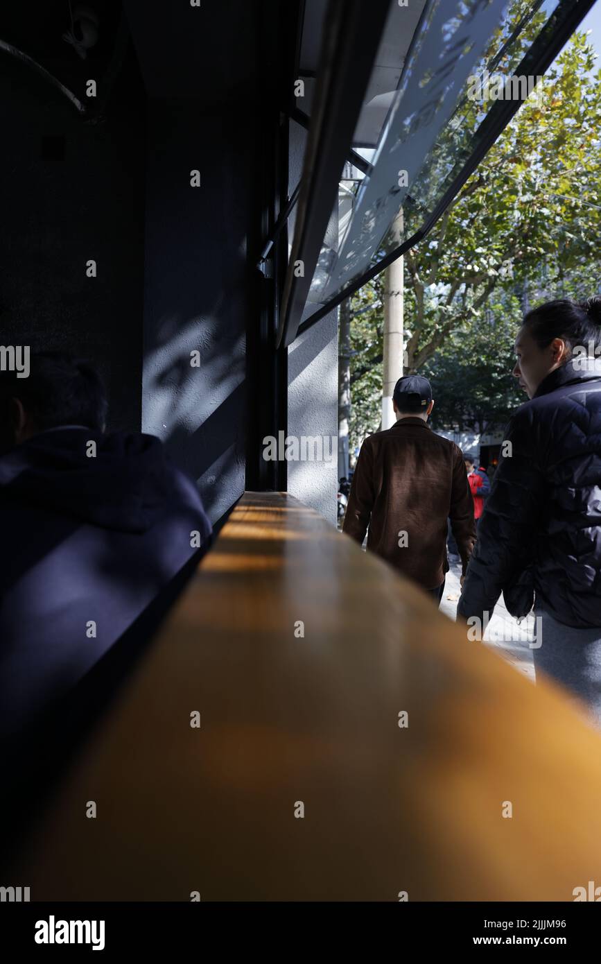 A wooden bar counter with people walking outside Stock Photo - Alamy