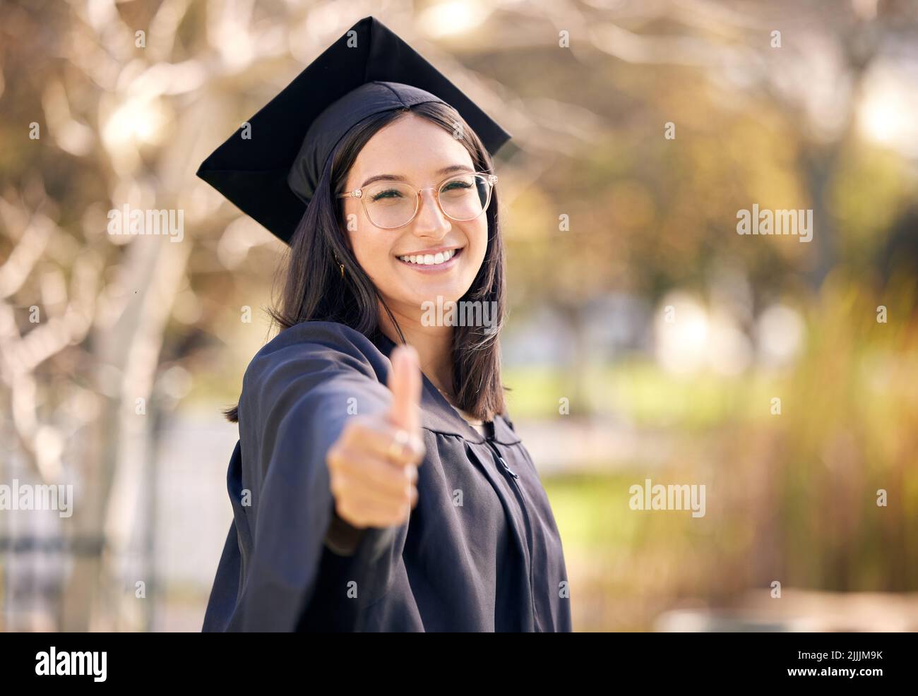 Certified goal getter. a young woman showing thumbs up on graduation ...