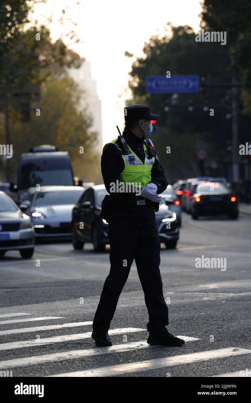 A police officer controlling traffic with a lot of cars in Shanghai ...