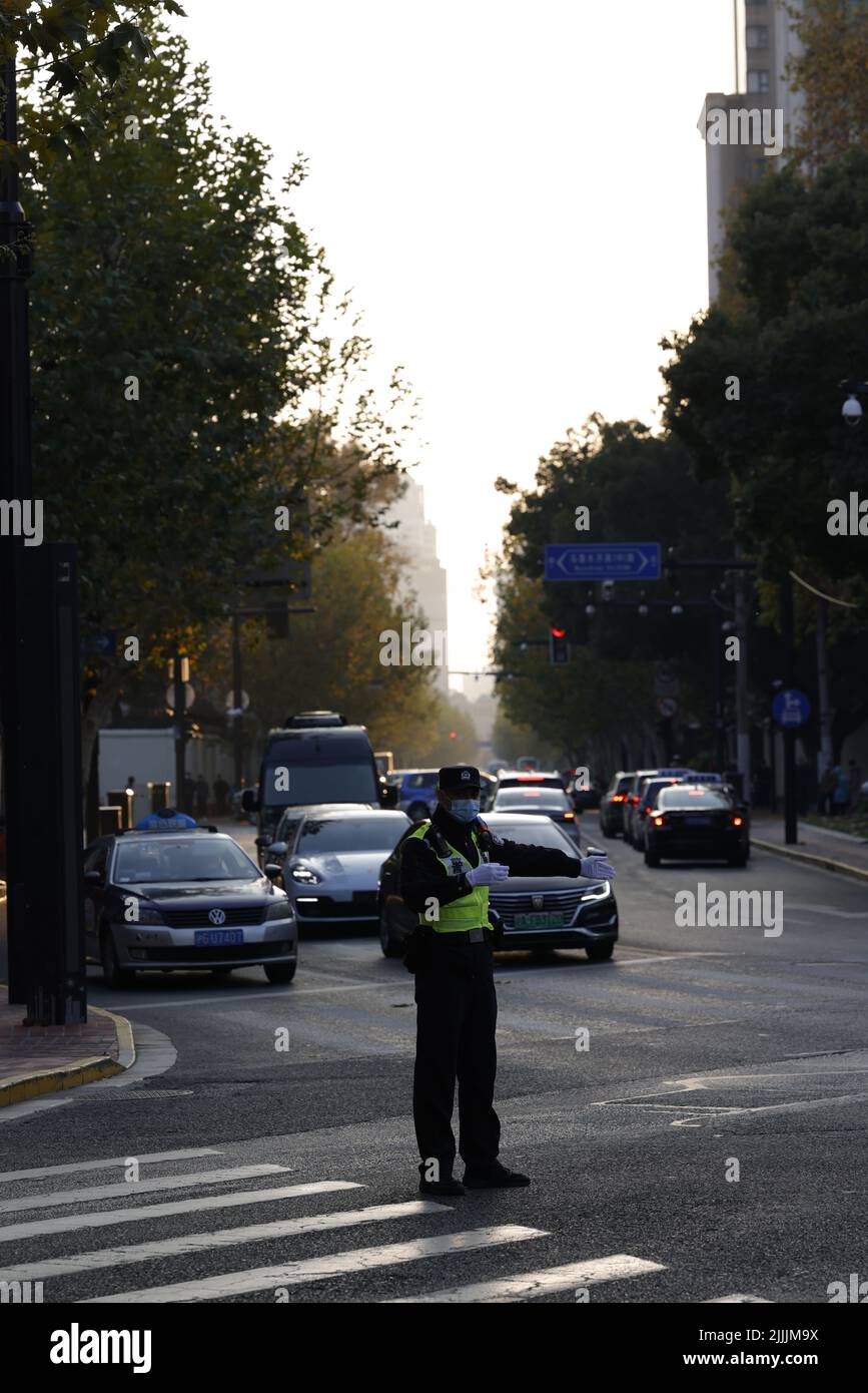 A police officer controlling traffic with a lot of cars in Shanghai ...