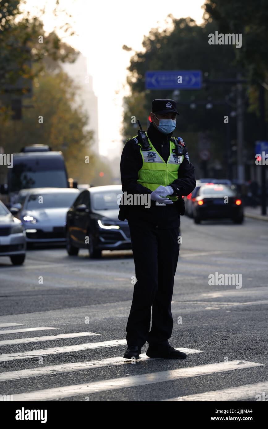 A police officer controlling traffic with a lot of cars in Shanghai ...