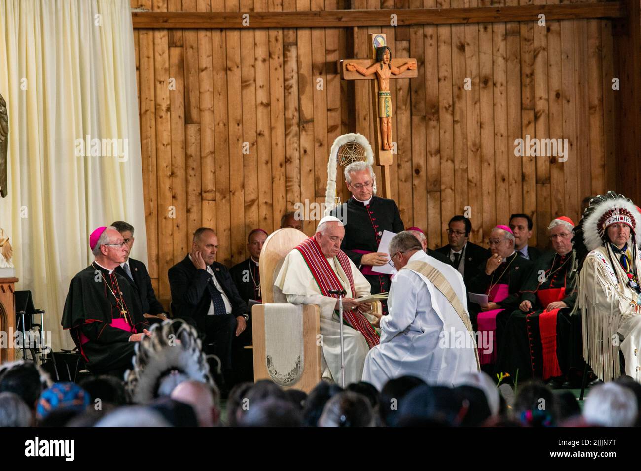 One of the priests assists Pope Francis in reading his missil. The pope ...