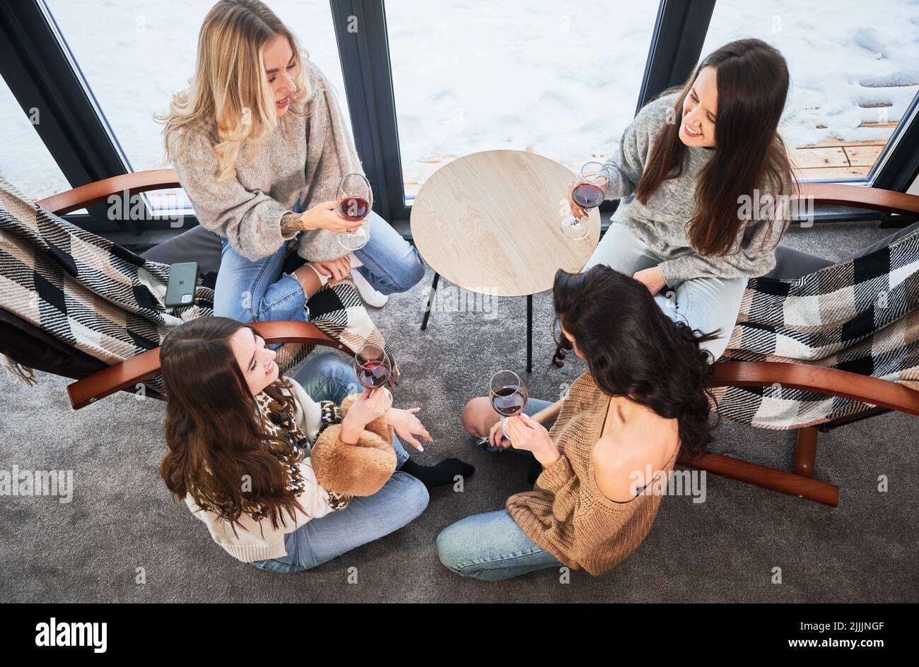 Young women enjoying winter weekends inside contemporary barn house ...