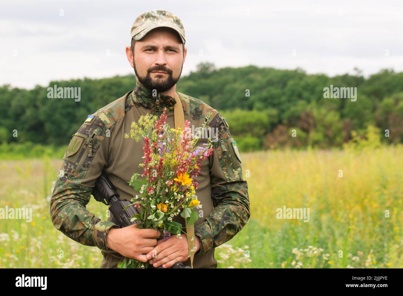 A Ukrainian soldier with a bouquet of wild flowers as a symbol of ...