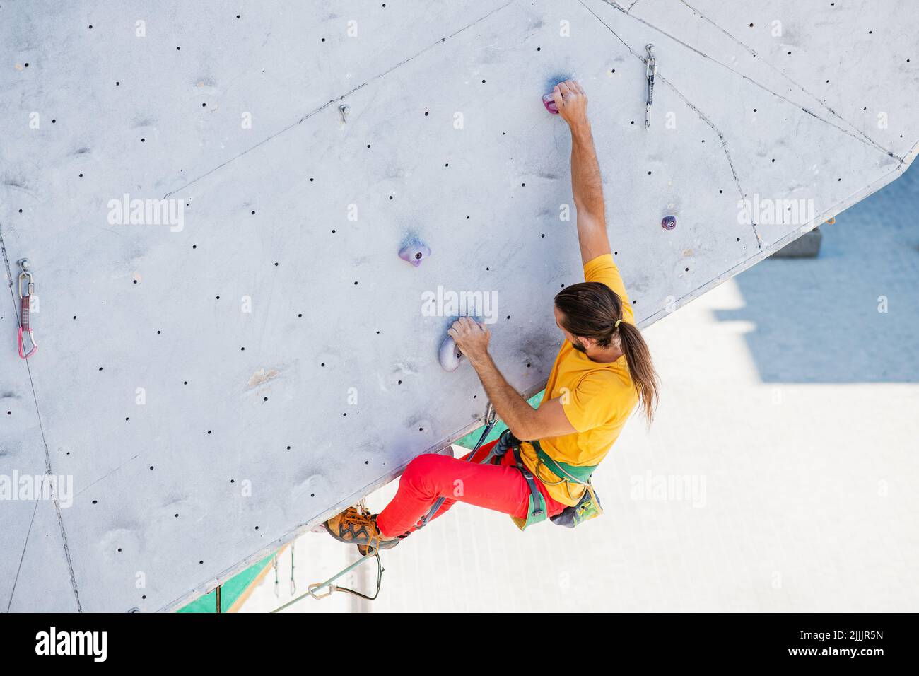 Sportsman climber moving up on steep rock, climbing on outdoor ...