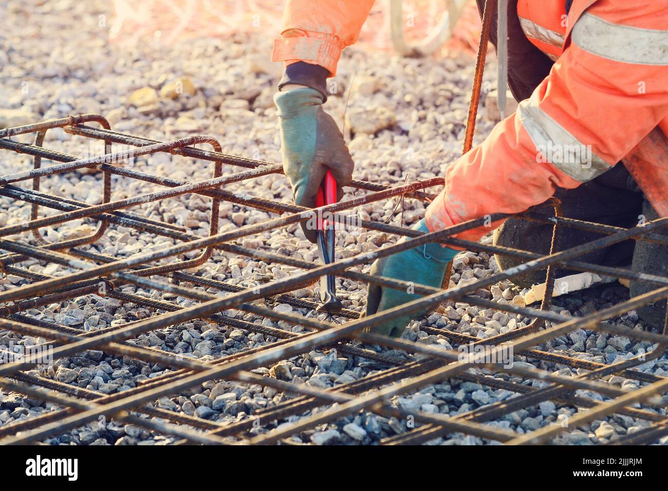 Builder's hands fixing steel reinforcement bars at construction site ...