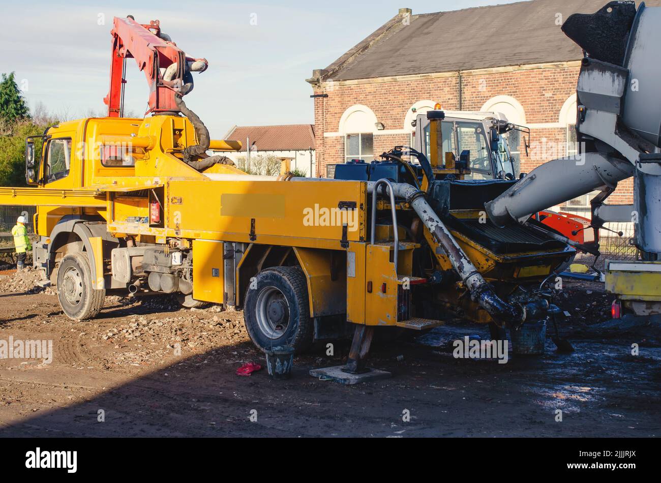 Wet concrete discharged from the mixing truck into the concrete pump ...