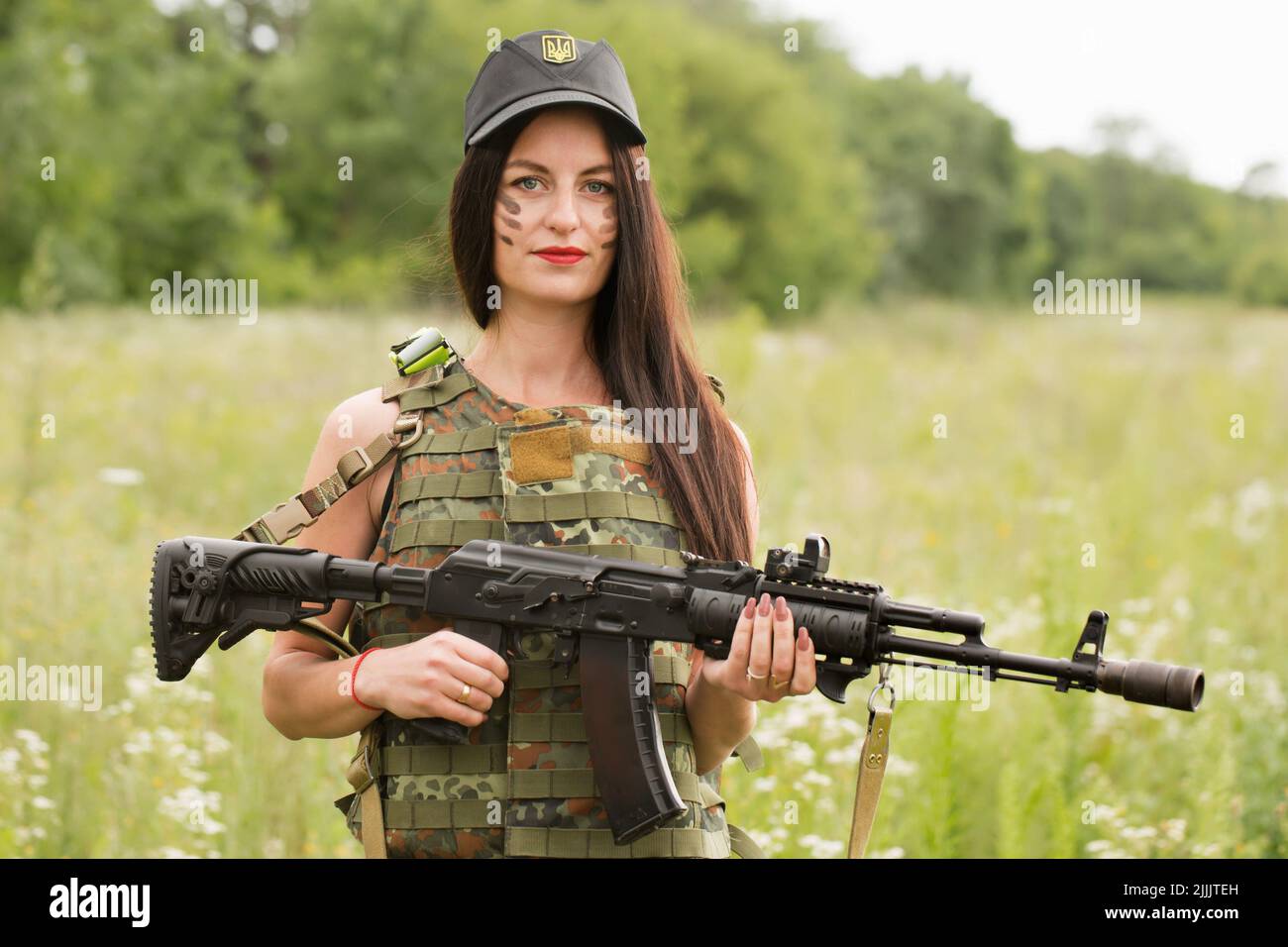 Ukrainian female military servicewoman with a machine gun in her hands ...