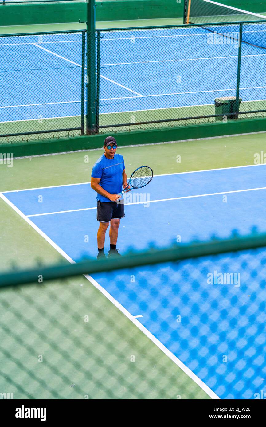 Portrait of middle aged positive male tennis player coach with racket ...