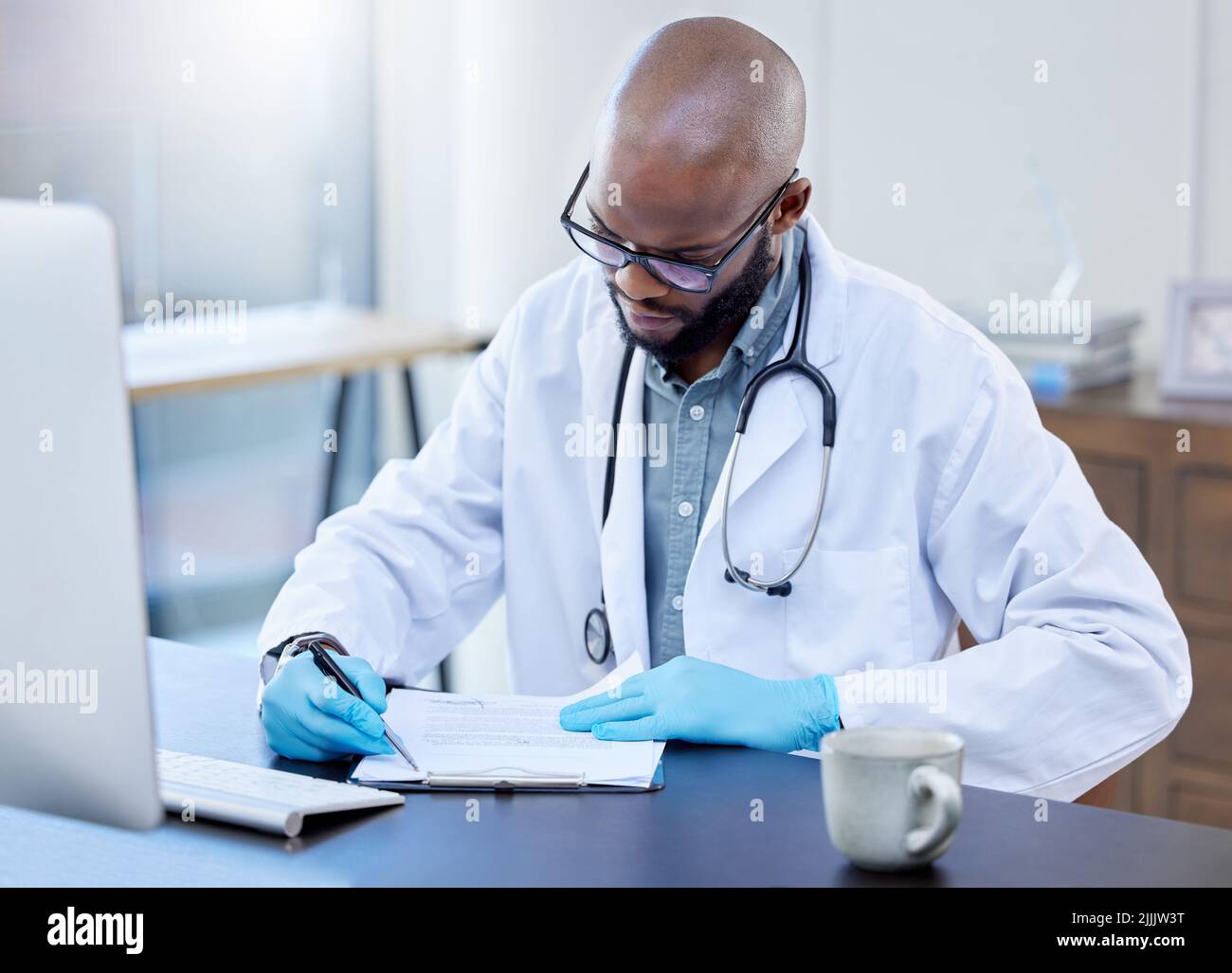 I have a few of these to sign. a male doctor filling out paperwork at ...