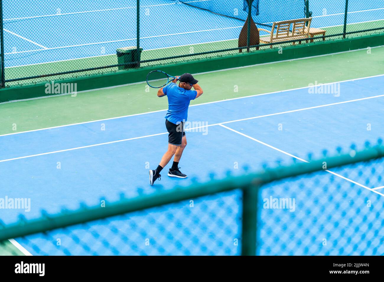 middle aged positive male tennis player coach with racket training at ...