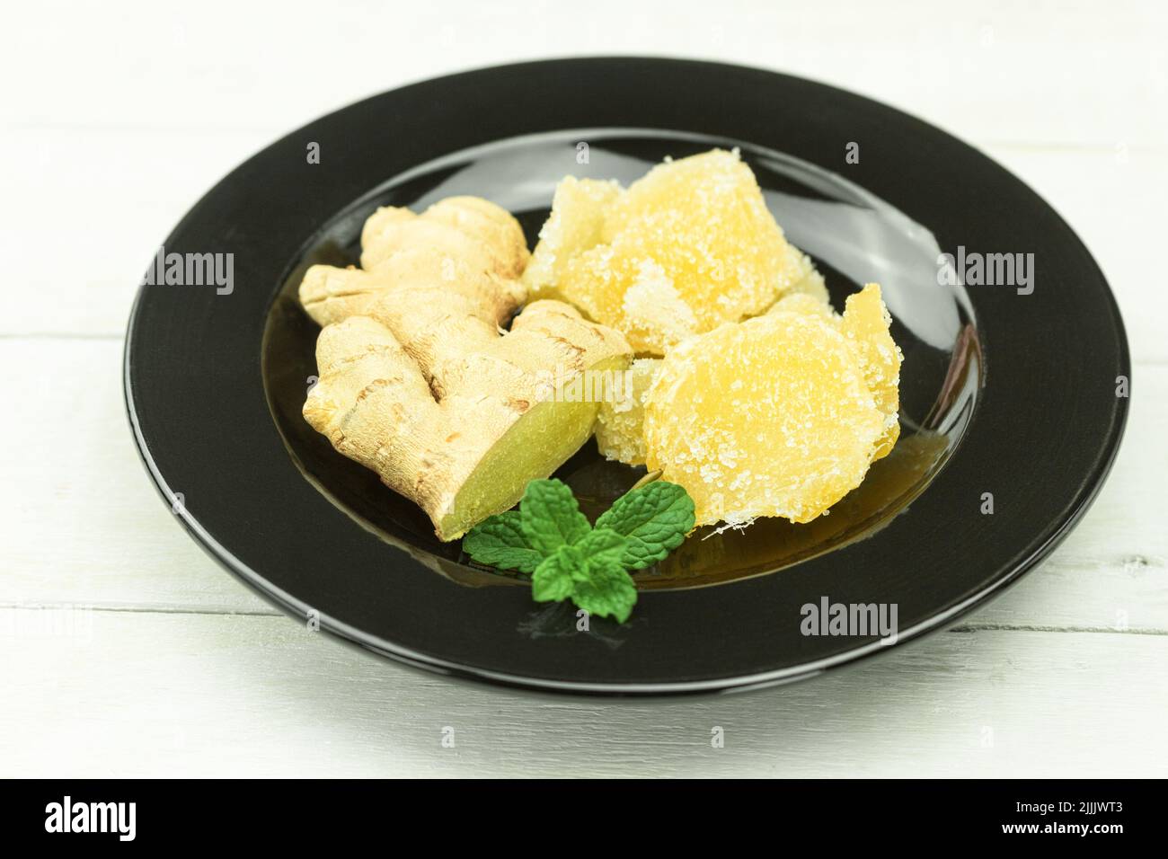 Fresh ginger root and candied ginger in sugar. Close-up of candied ...