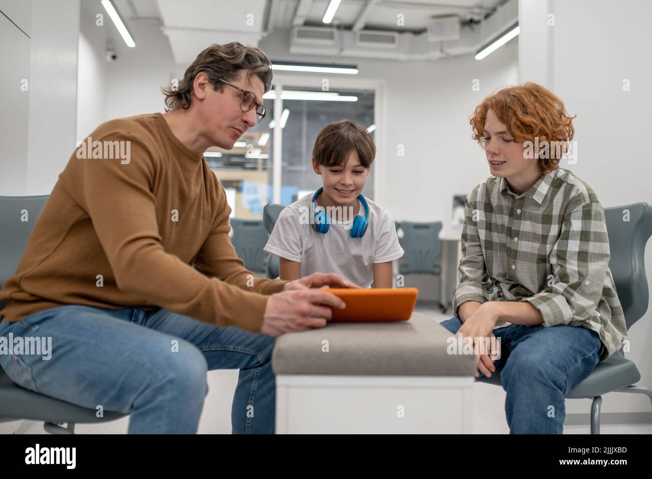 Teacher in eyeglasses explaining something to his students Stock Photo ...
