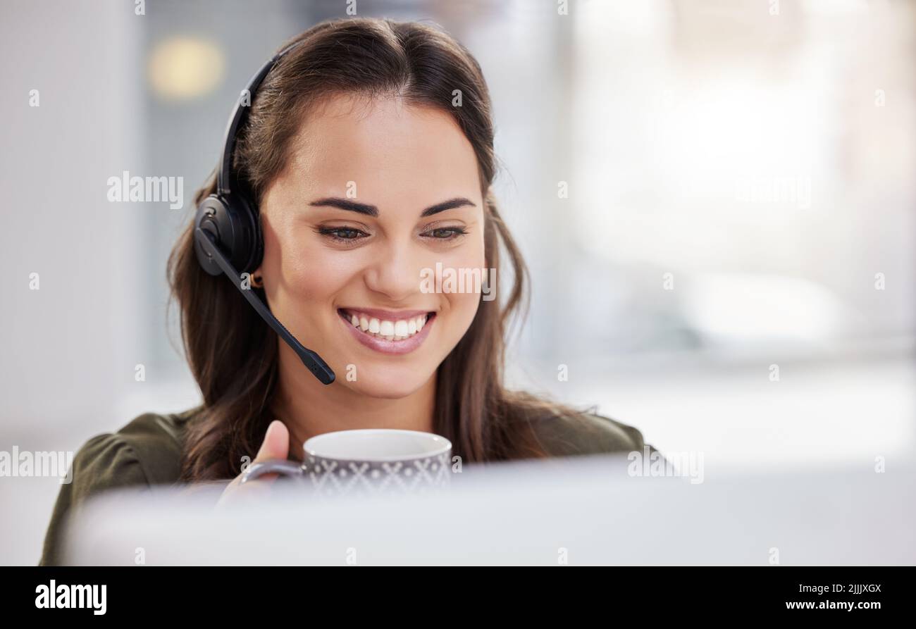 Customer care is what shes good at. a young call centre agent drinking ...