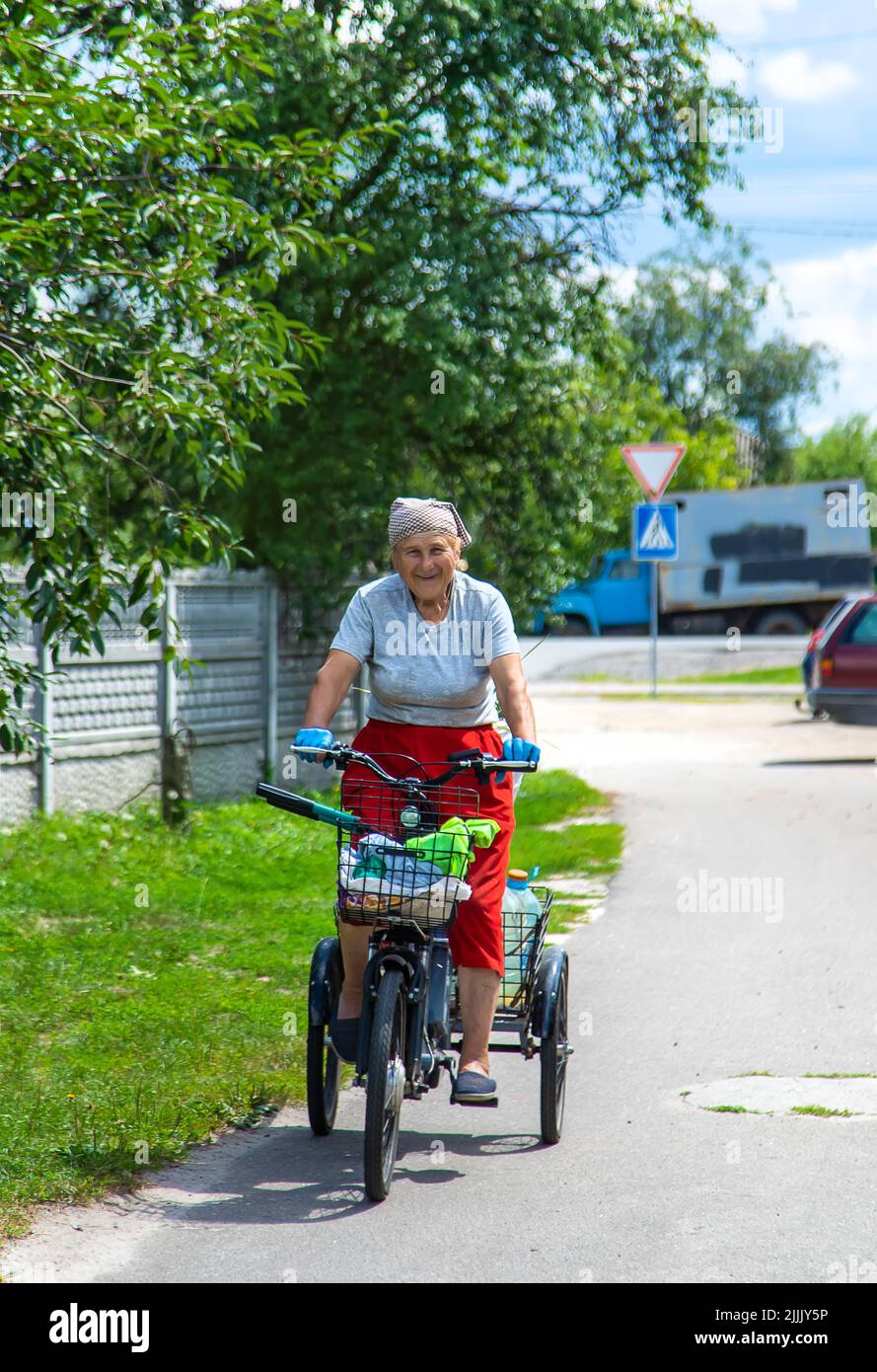 An old woman rides a bicycle. Selection focus. Nature Stock Photo - Alamy