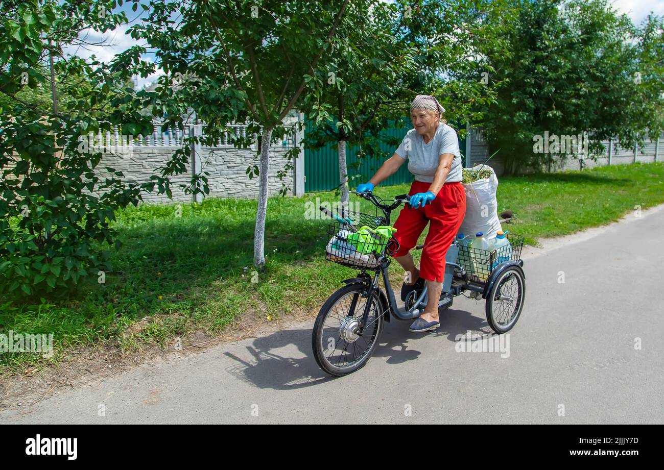 An old woman rides a bicycle. Selection focus. Nature Stock Photo - Alamy