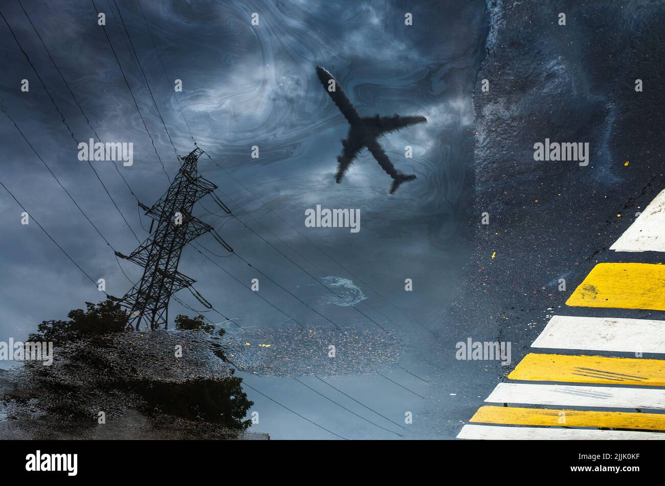 Reflection of a street with flying airplane, a high-voltage tower and a ...
