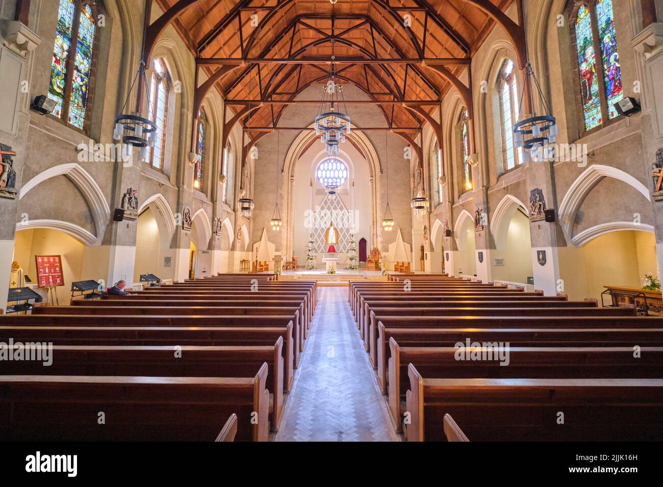 A view of the center aisle with wood pews and the altar in the distance ...
