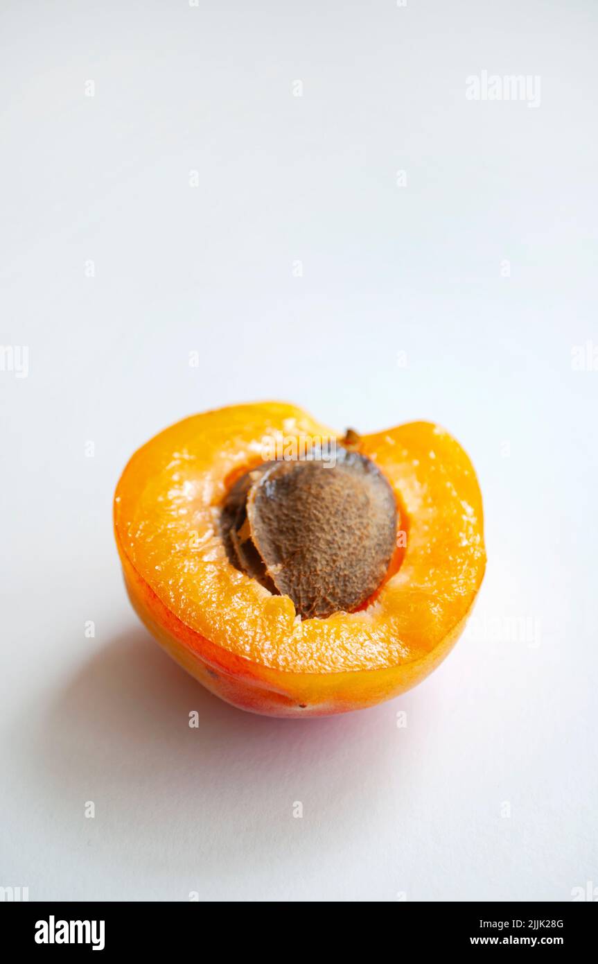 A ripe cut apricot with a seed on white background Stock Photo - Alamy