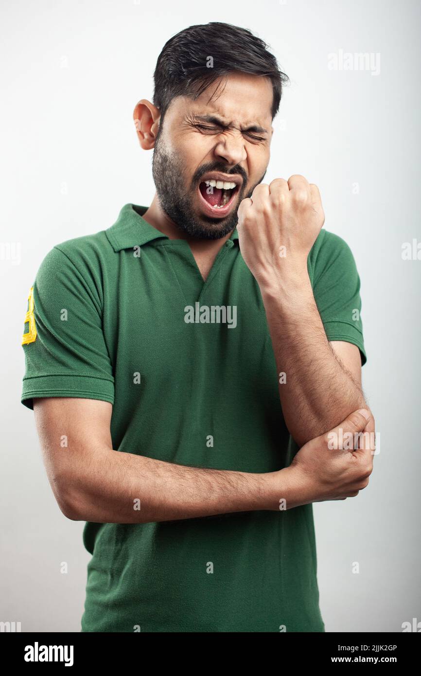 A man showing elbow joint pain with a grimaced expression Stock Photo ...