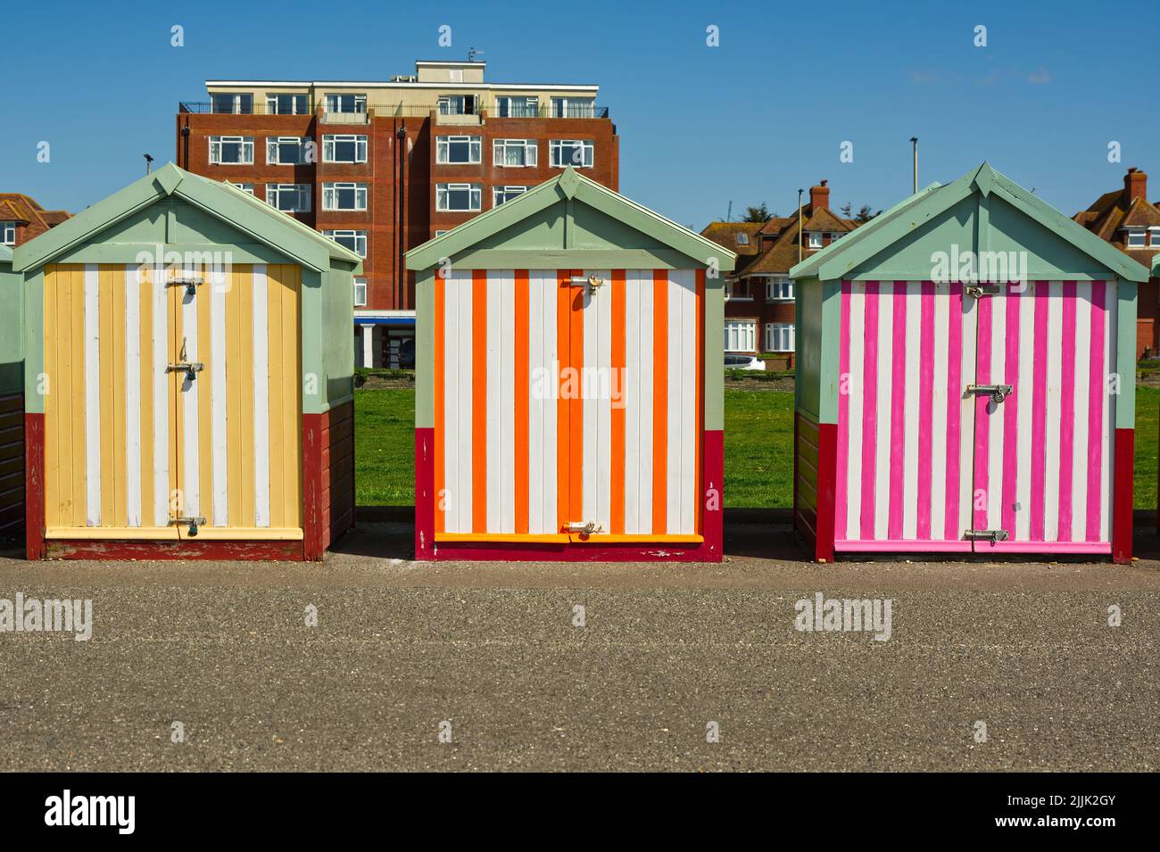 Multicoloured beach huts on the seafront promenade at Hove in Brighton ...