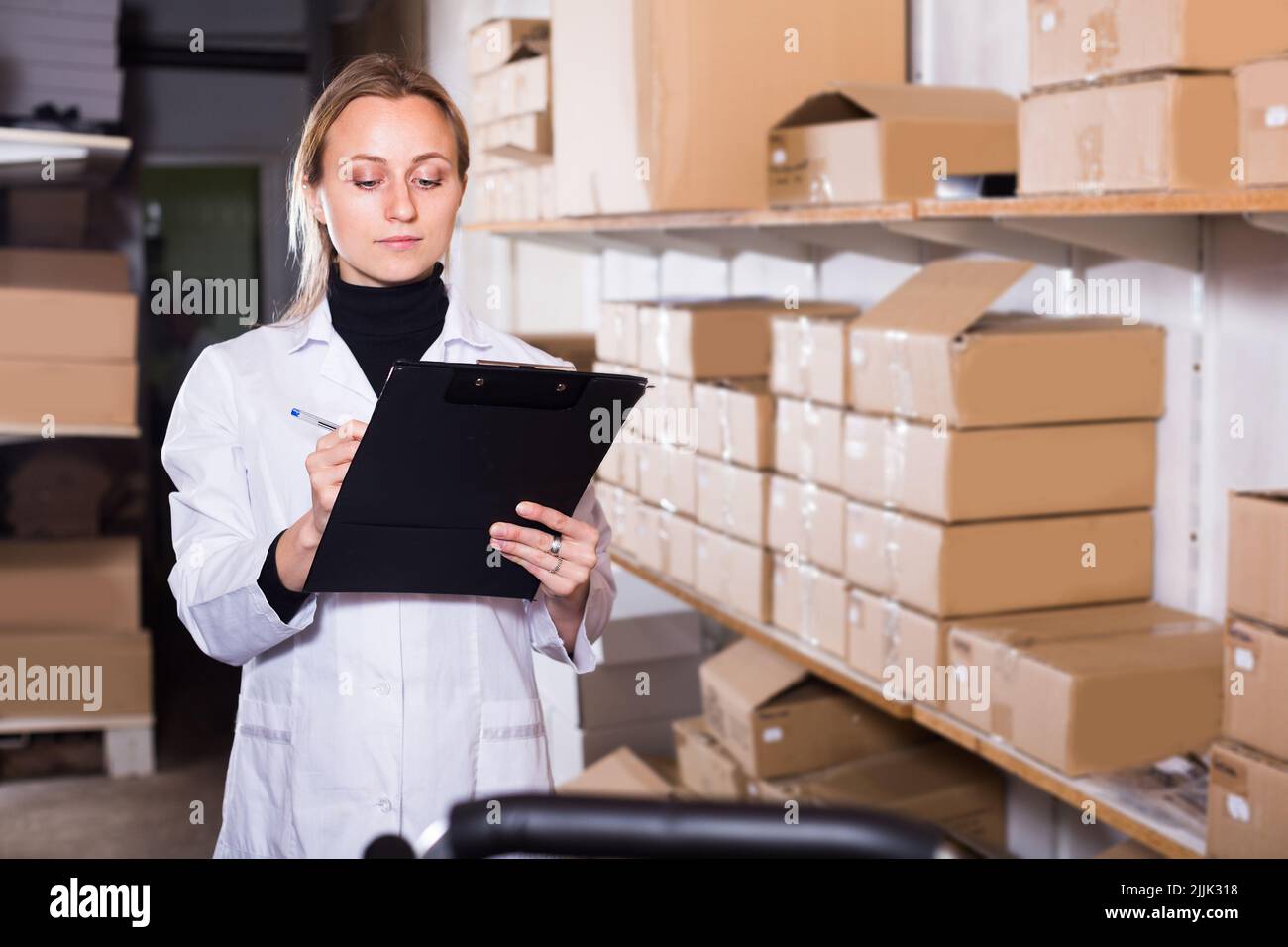 Female standing with notepad in production workshop Stock Photo - Alamy