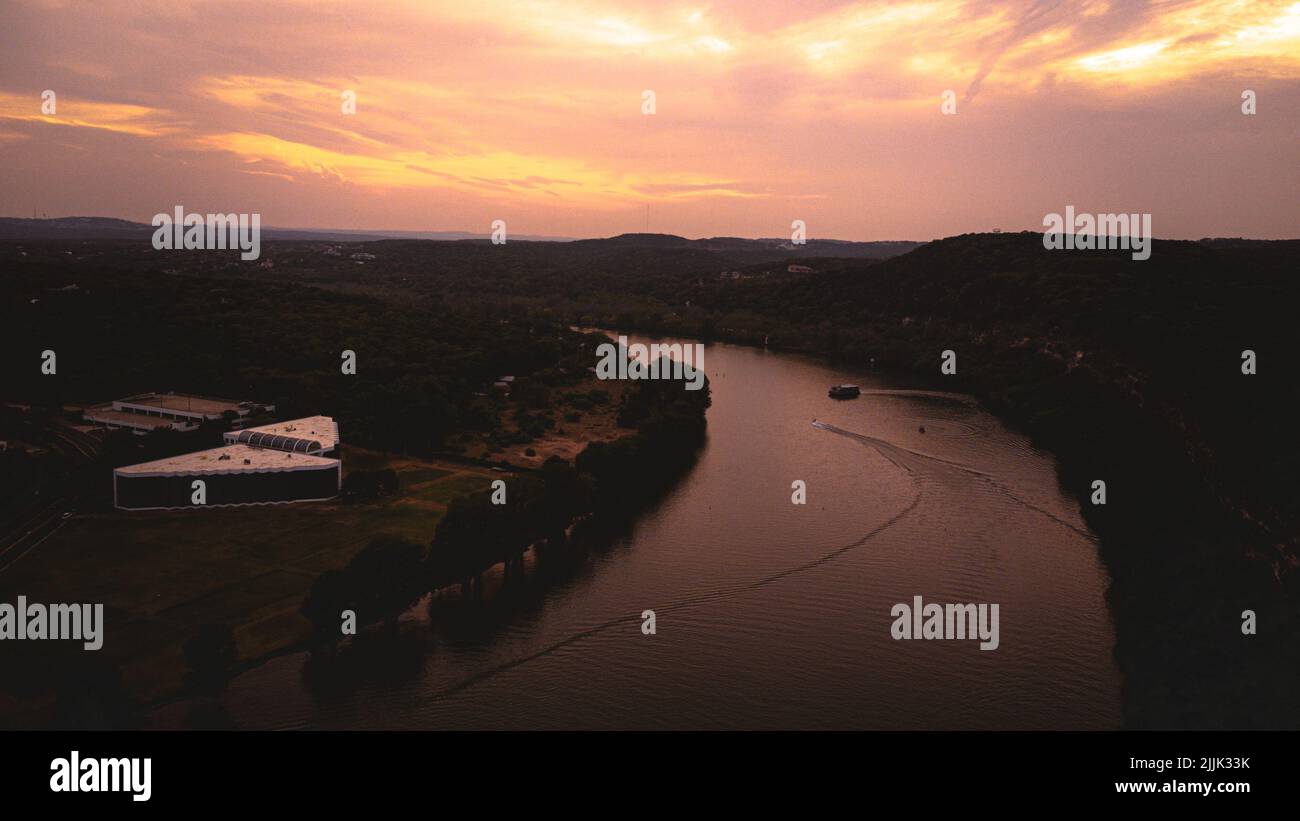 An aerial view of Austin river surrounded by growing trees during ...