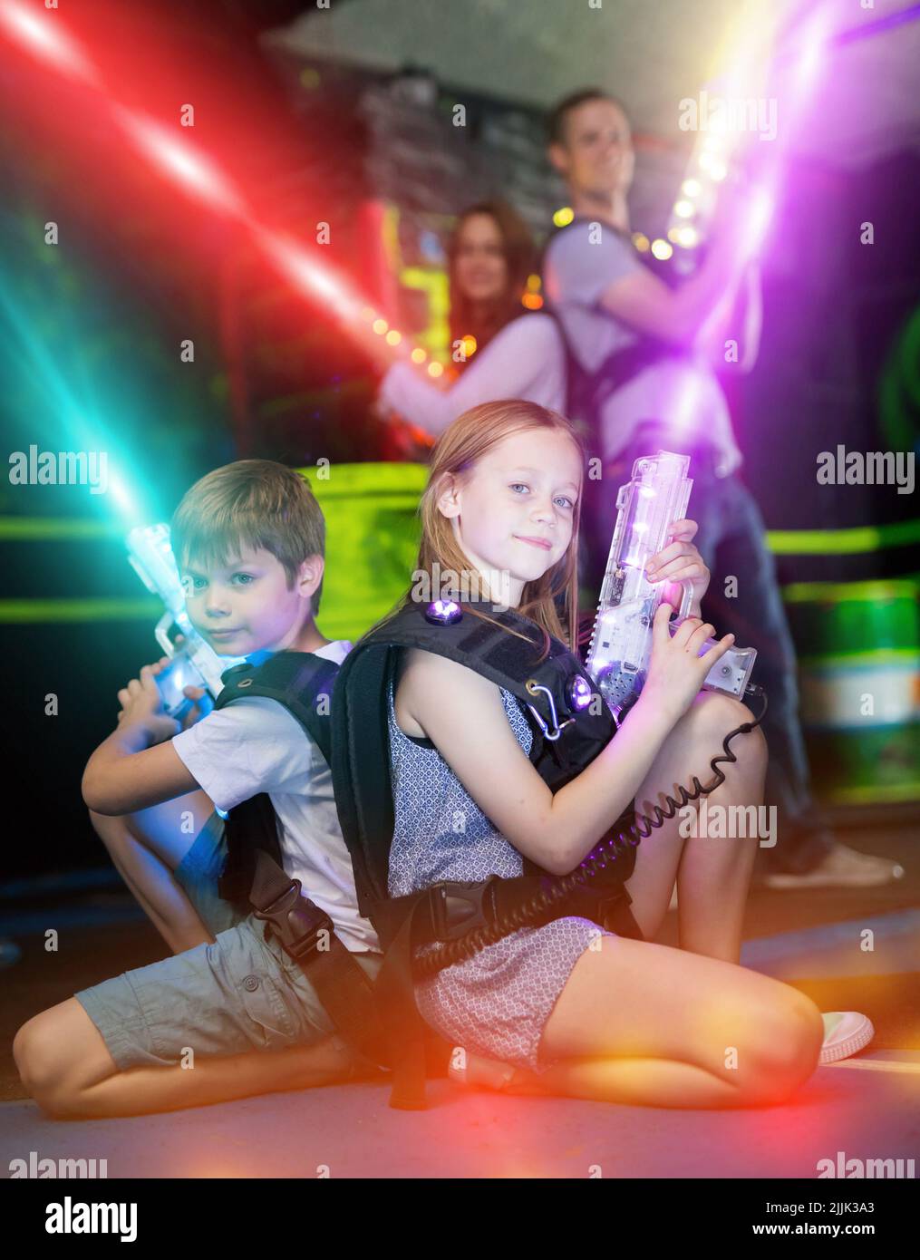 Kids sitting back to back on beams with laser pistols Stock Photo - Alamy