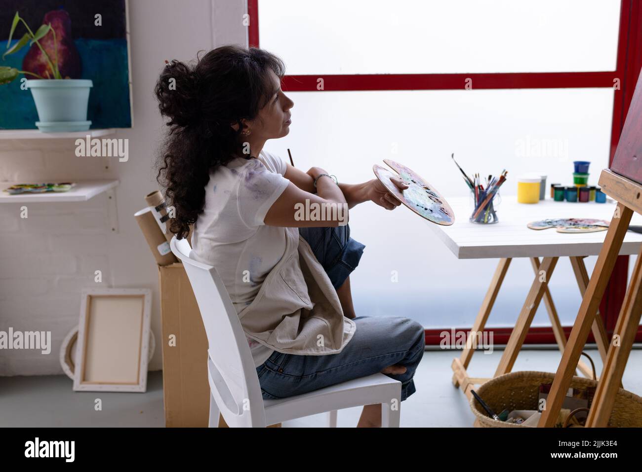 Image of biracial female artist working on new painting in studio Stock ...