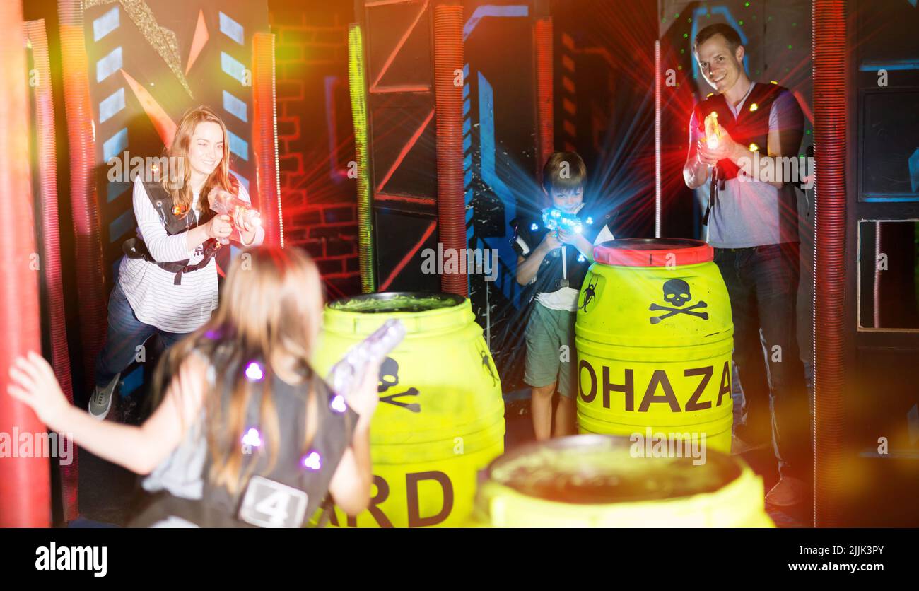 Parents and children playing laser tag in beams Stock Photo - Alamy