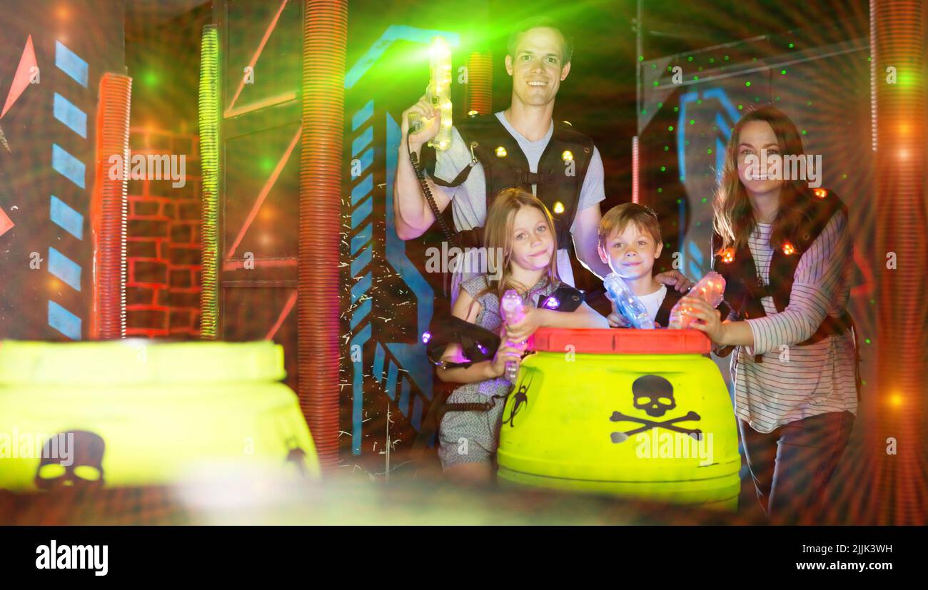 Parents and children playing laser tag in beams Stock Photo - Alamy