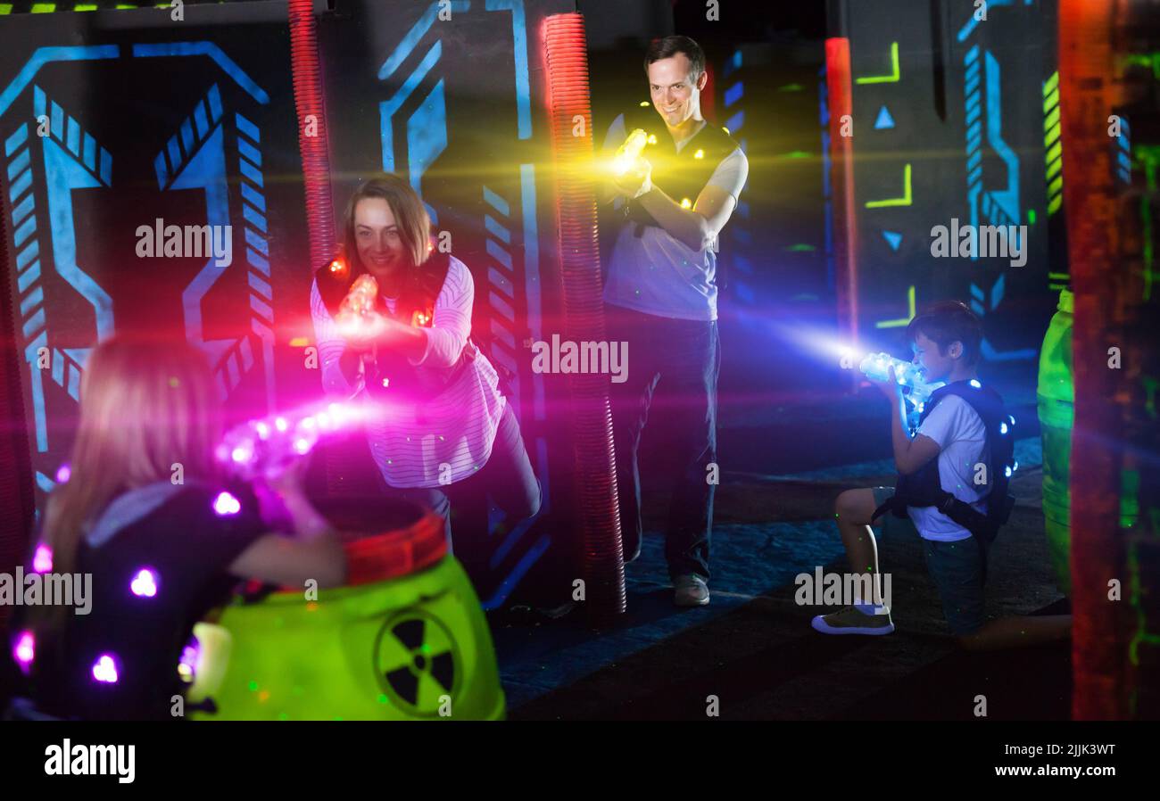 Parents and children playing laser tag in beams Stock Photo - Alamy