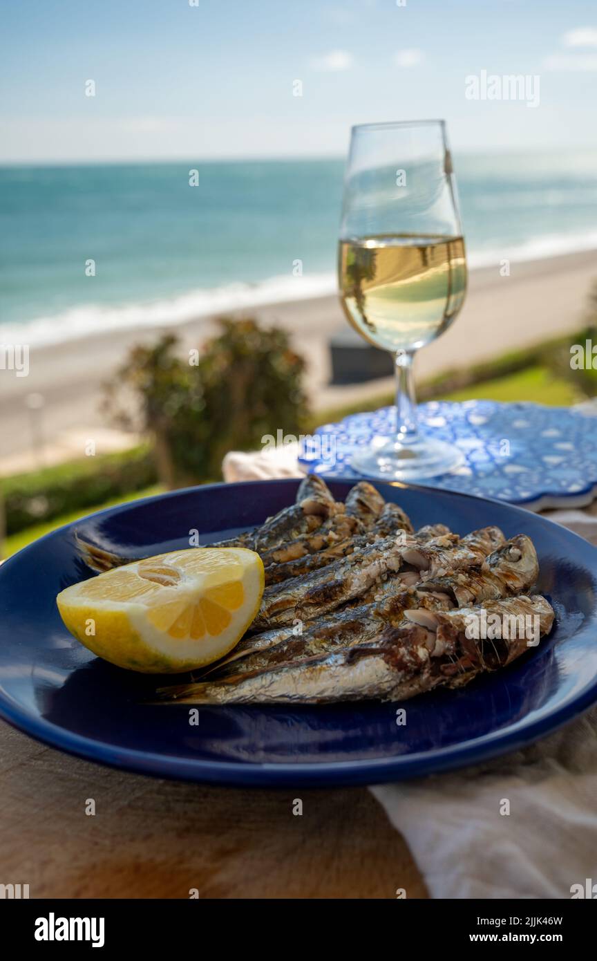 Sardines espeto prepared on skewers and open flame on fireplace with ...