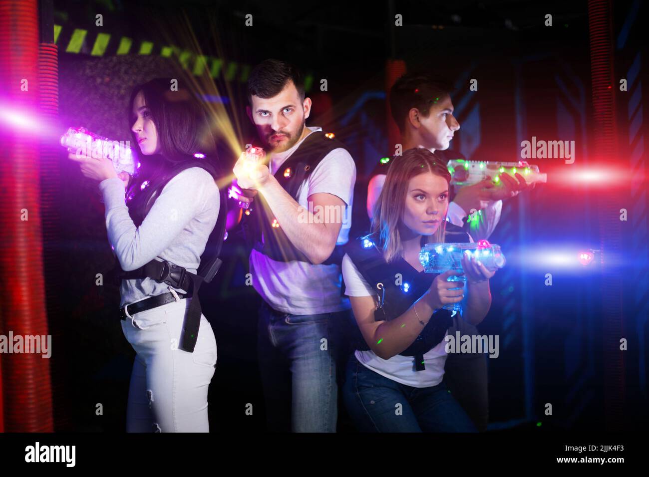 Young people on lasertag in colorful beams Stock Photo - Alamy