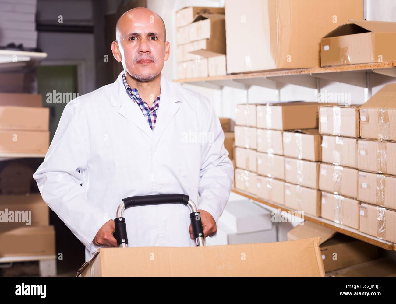 Worker performing loading works in storage Stock Photo - Alamy