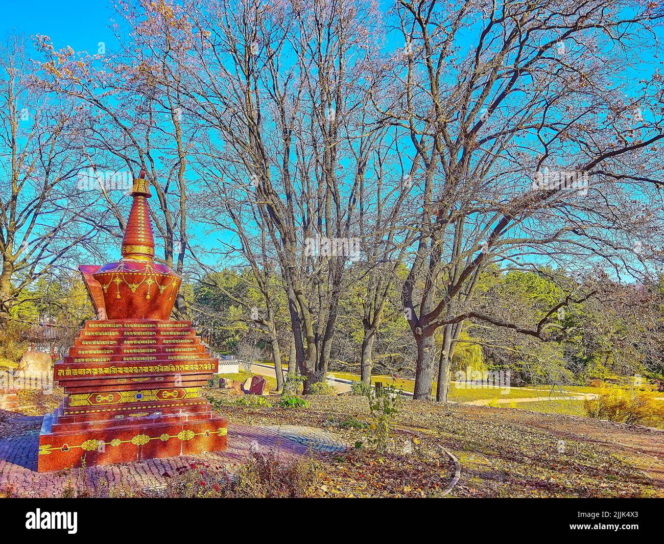 The scenic red granite Chorten (stupa), decorated with gilt patterns ...
