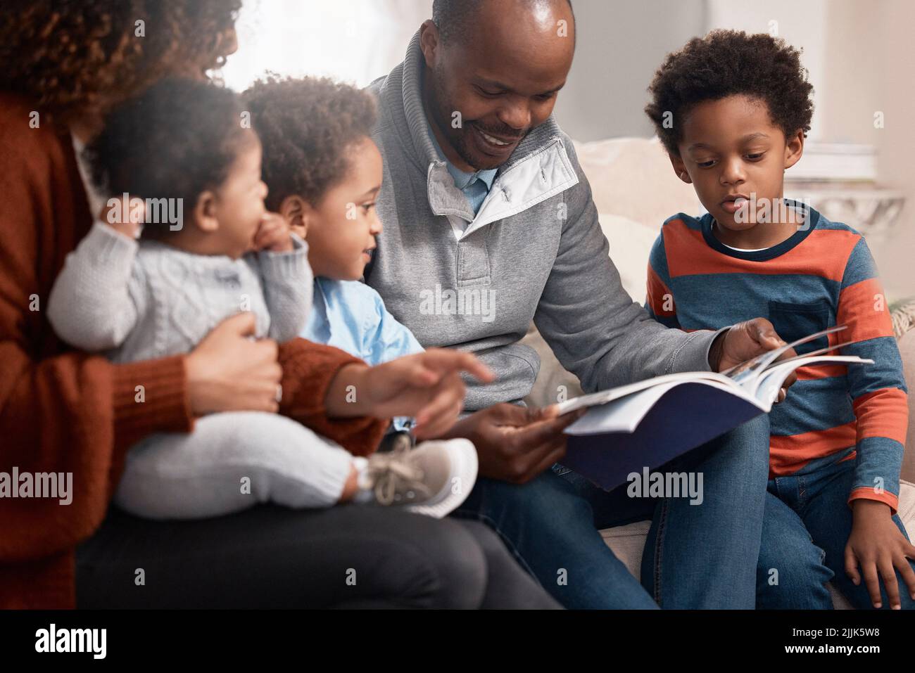 Storytime is quality time. a father reading a book to his family at ...