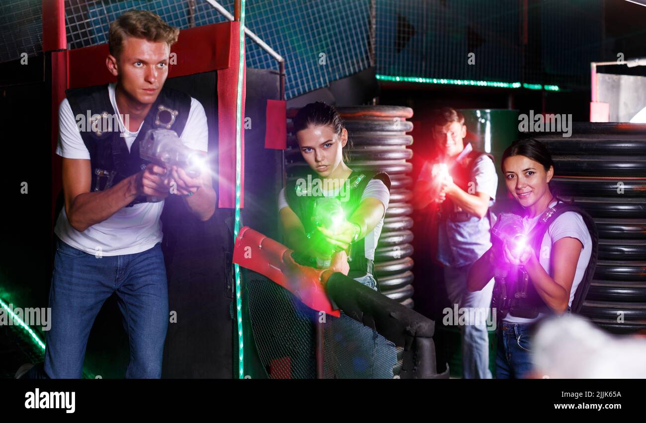 friends playing laser tag game with laser guns near tires Stock Photo ...