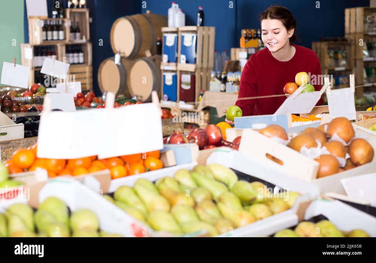 Portrait of young customer selecting apple in grocery Stock Photo - Alamy