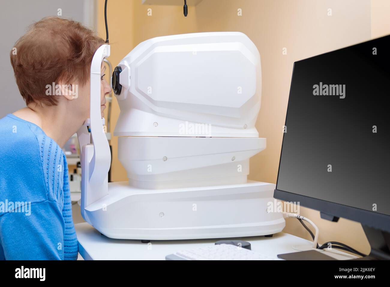An adult woman at an ophthalmologist's appointment checks her vision on ...