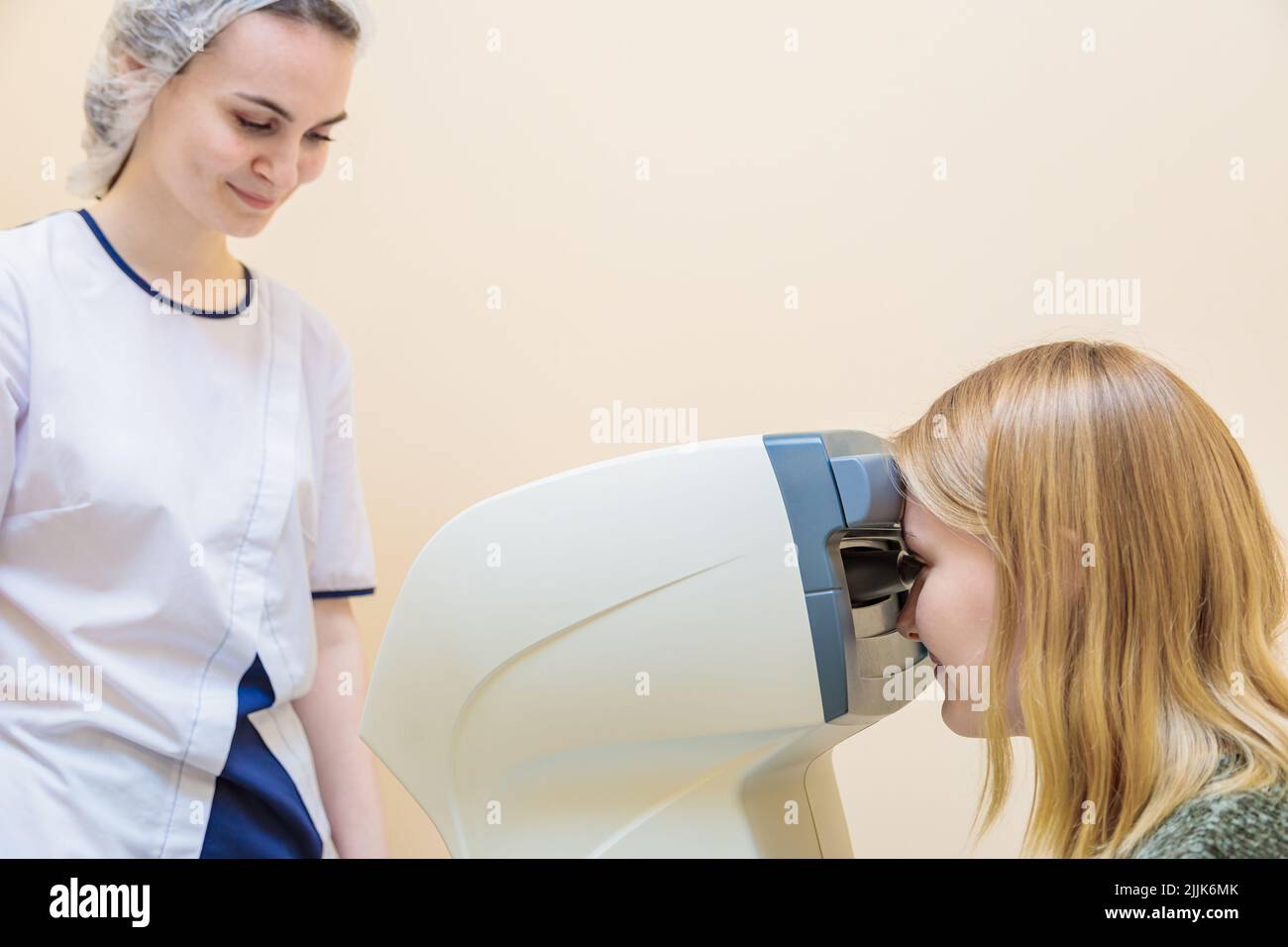 A girl optometrist examines the eyes of a patient using special modern ...