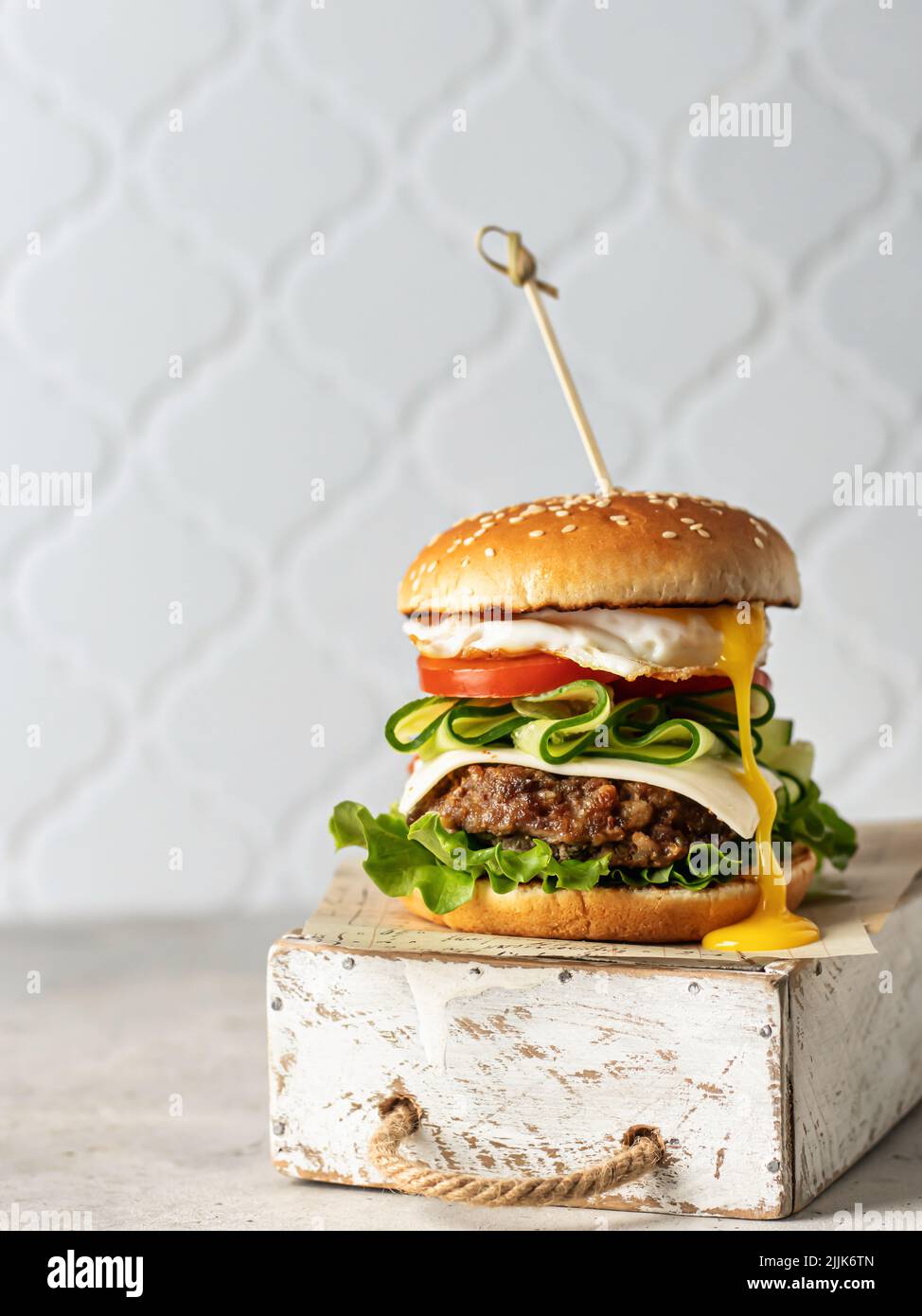 Yummy big burger with lettuce, cutlet, cheese, vegetables and egg with ...