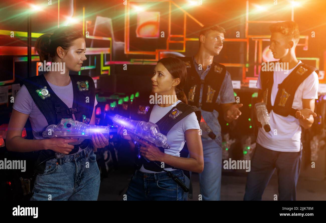 Two girls talking during laser tag game Stock Photo - Alamy